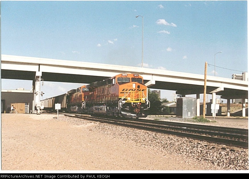 BNSF 5973 and BNSF 5968 roll under the bridge as they head west